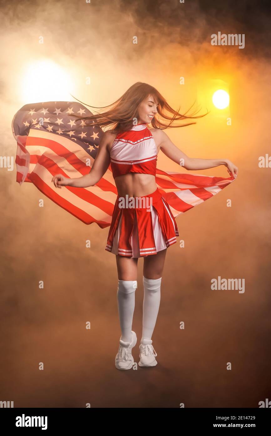 Beautiful young cheerleader with USA flag in smoke Stock Photo - Alamy