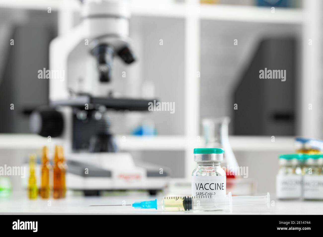 Vaccine in vial for injection on table against background of laboratory ...