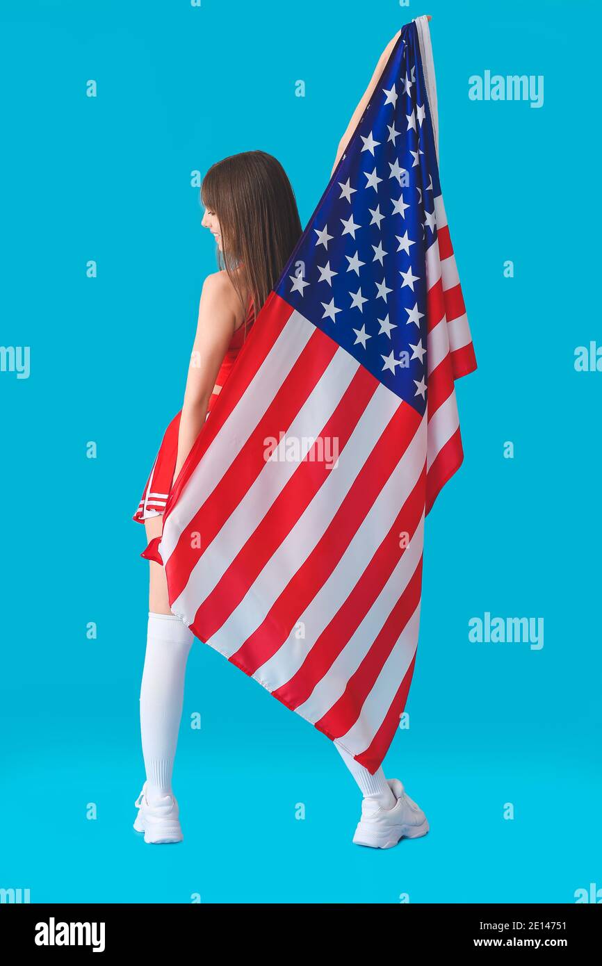 Beautiful young cheerleader with USA flag on color background Stock ...