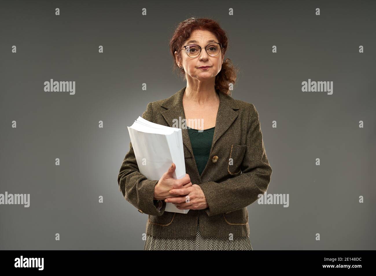 Senior teacher holding exam results with a severe expression Stock ...