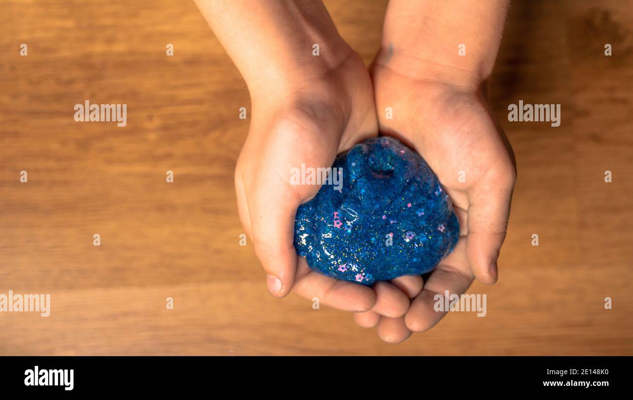 children show blue slime with stars glitters in hands. Kids hands ...