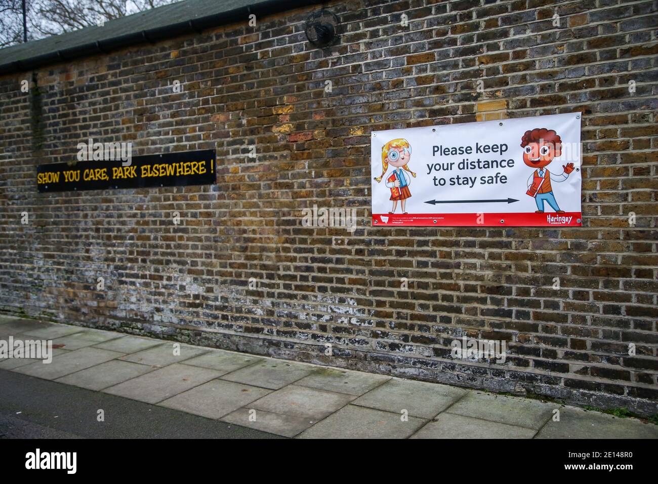 A 'Please keep your distance to stay safe' sign displayed on a railings ...