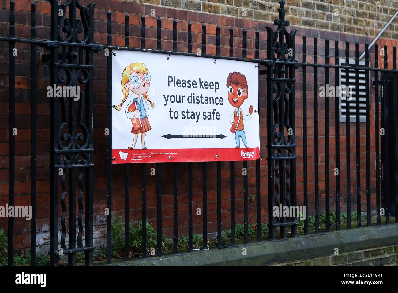 A 'Please keep your distance to stay safe' sign displayed on a railings ...