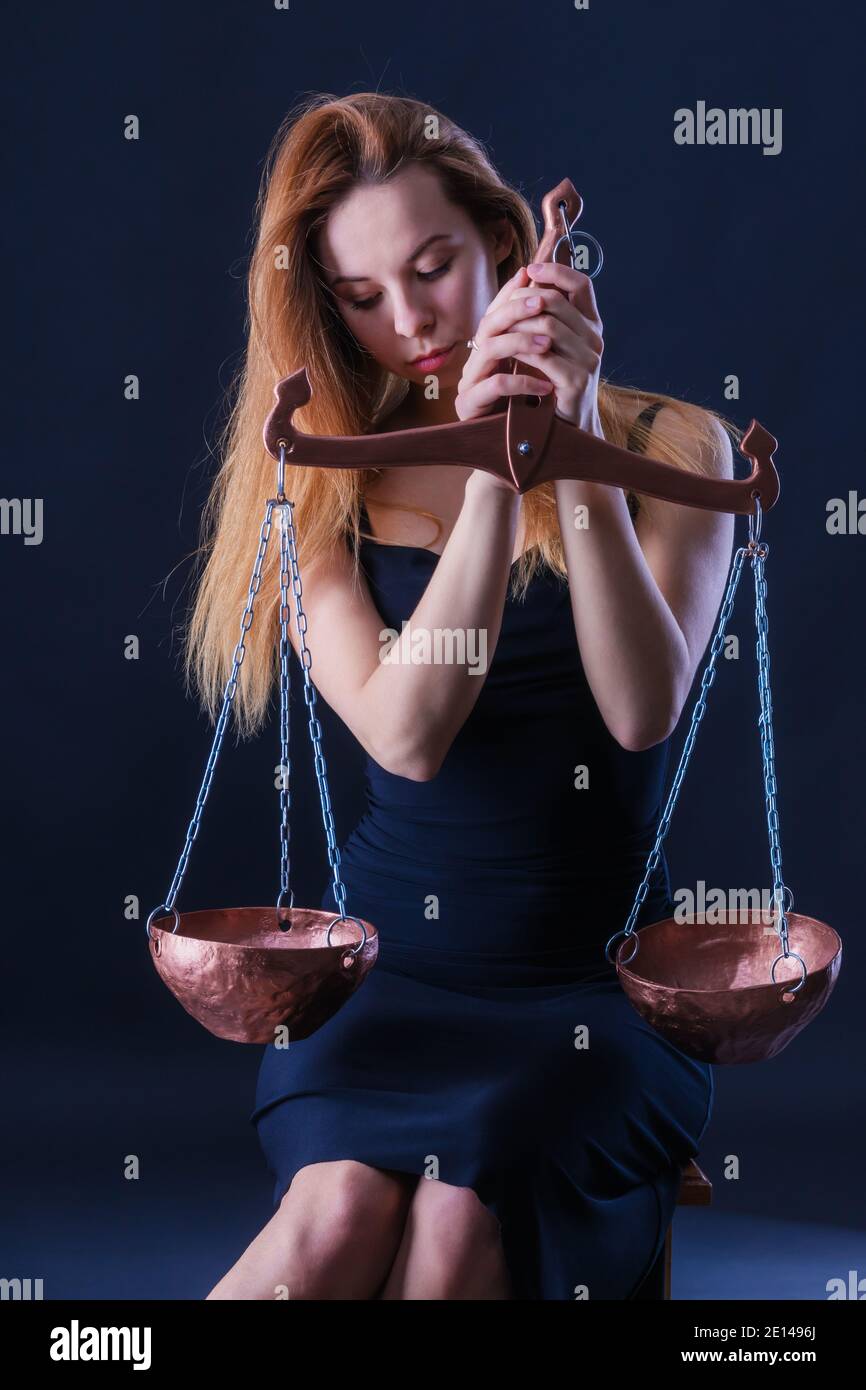 Seated charming girl with Libra in her hand as a symbol of the air ...