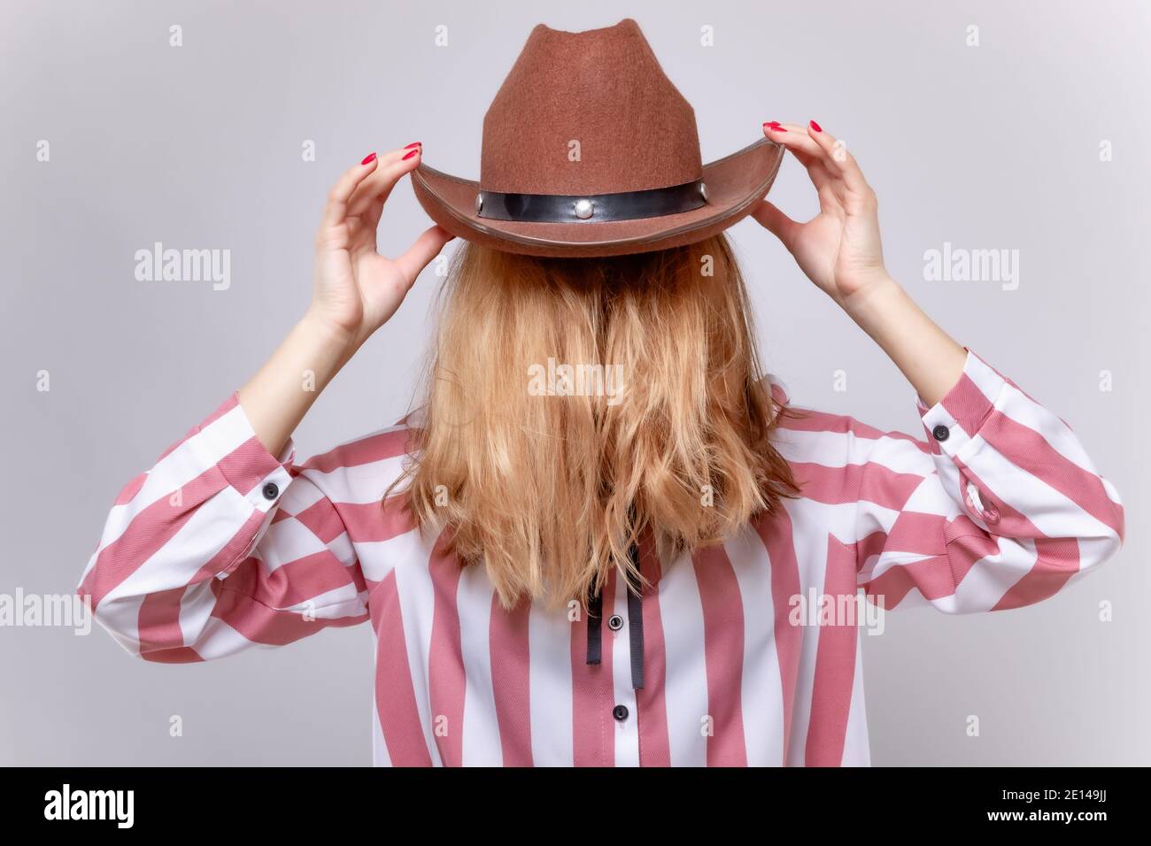 Girl in a cowboy hat with her head turned 180 degrees Stock Photo - Alamy
