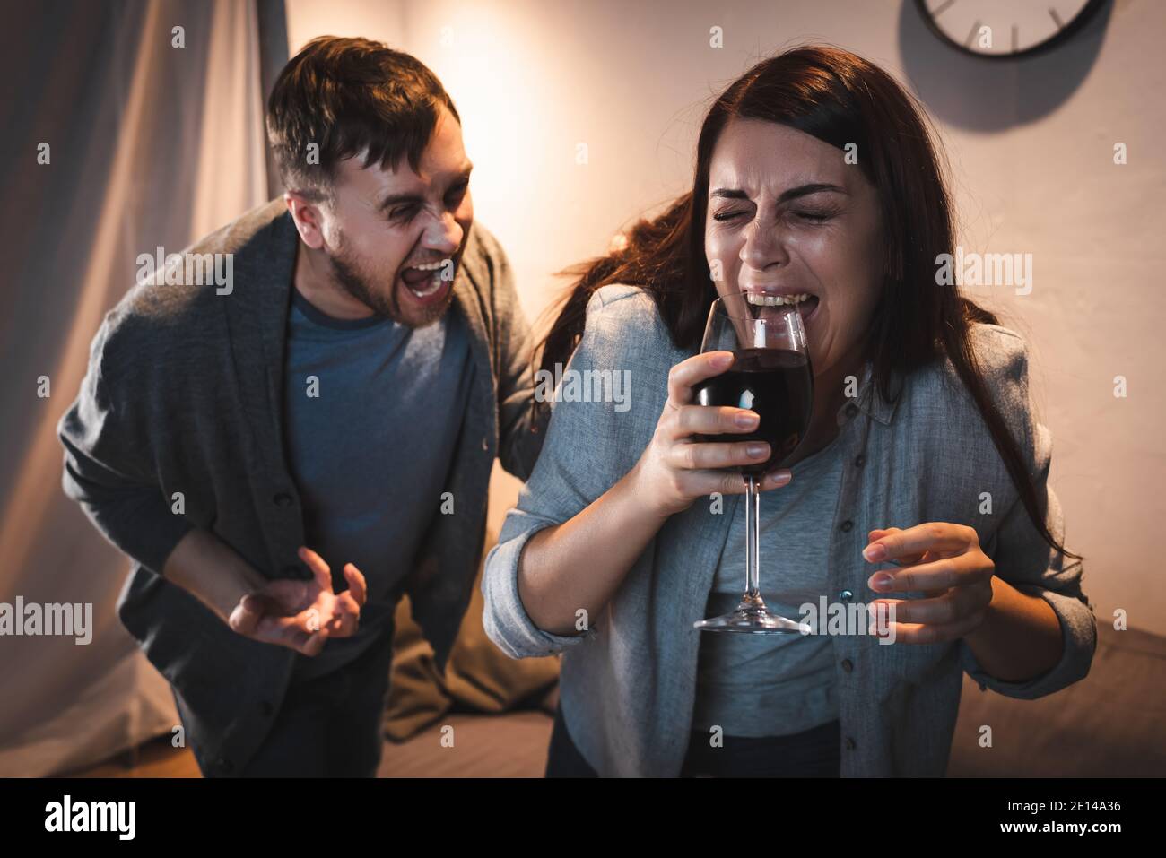 drunk man screaming at alcohol-addicted wife holding wine glass with ...