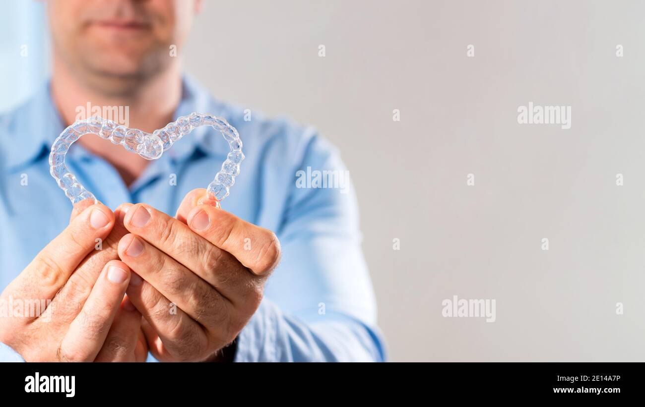 Doctor orthodontist makes a heart shape from aligners for teeth Stock ...