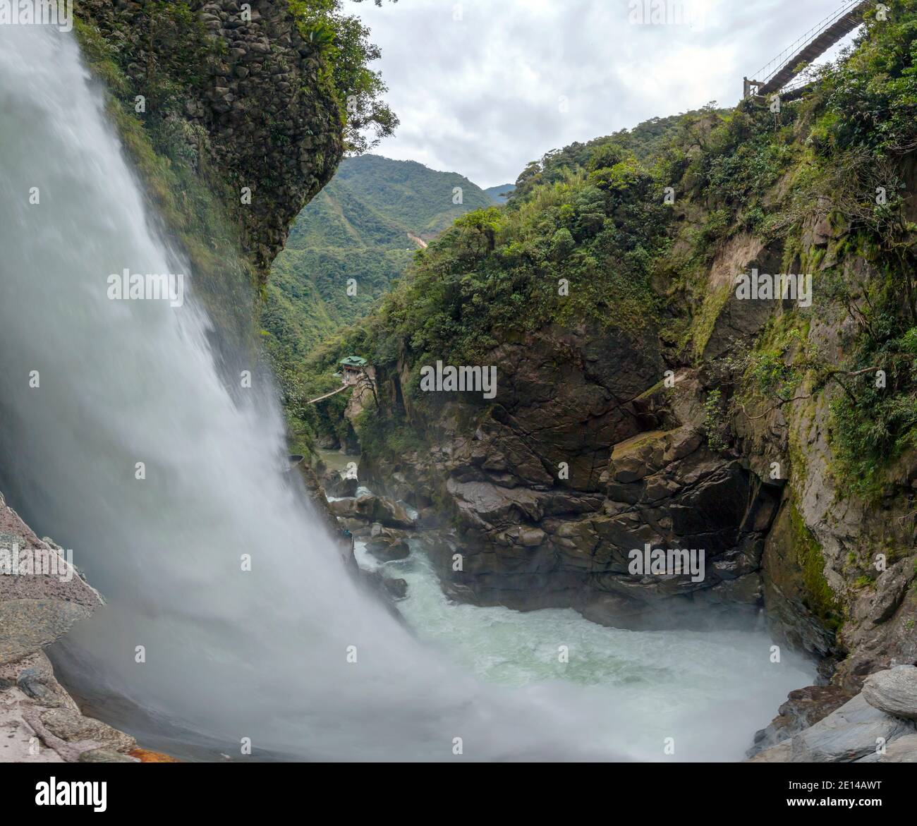 The Pailon del Diablo Waterfall with tourists watching from balconies ...