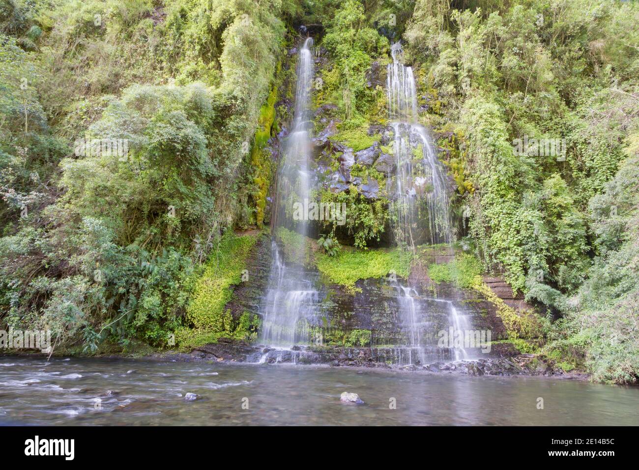 Waterfall running down a cliff from a spring high on the valley side ...