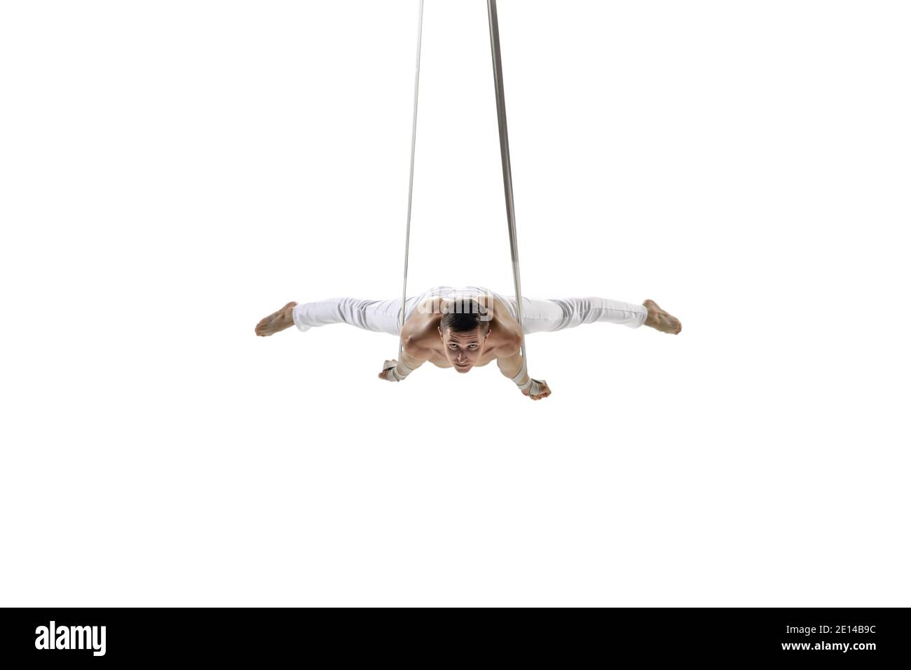 Strong. Young male acrobat, circus athlete isolated on white studio ...