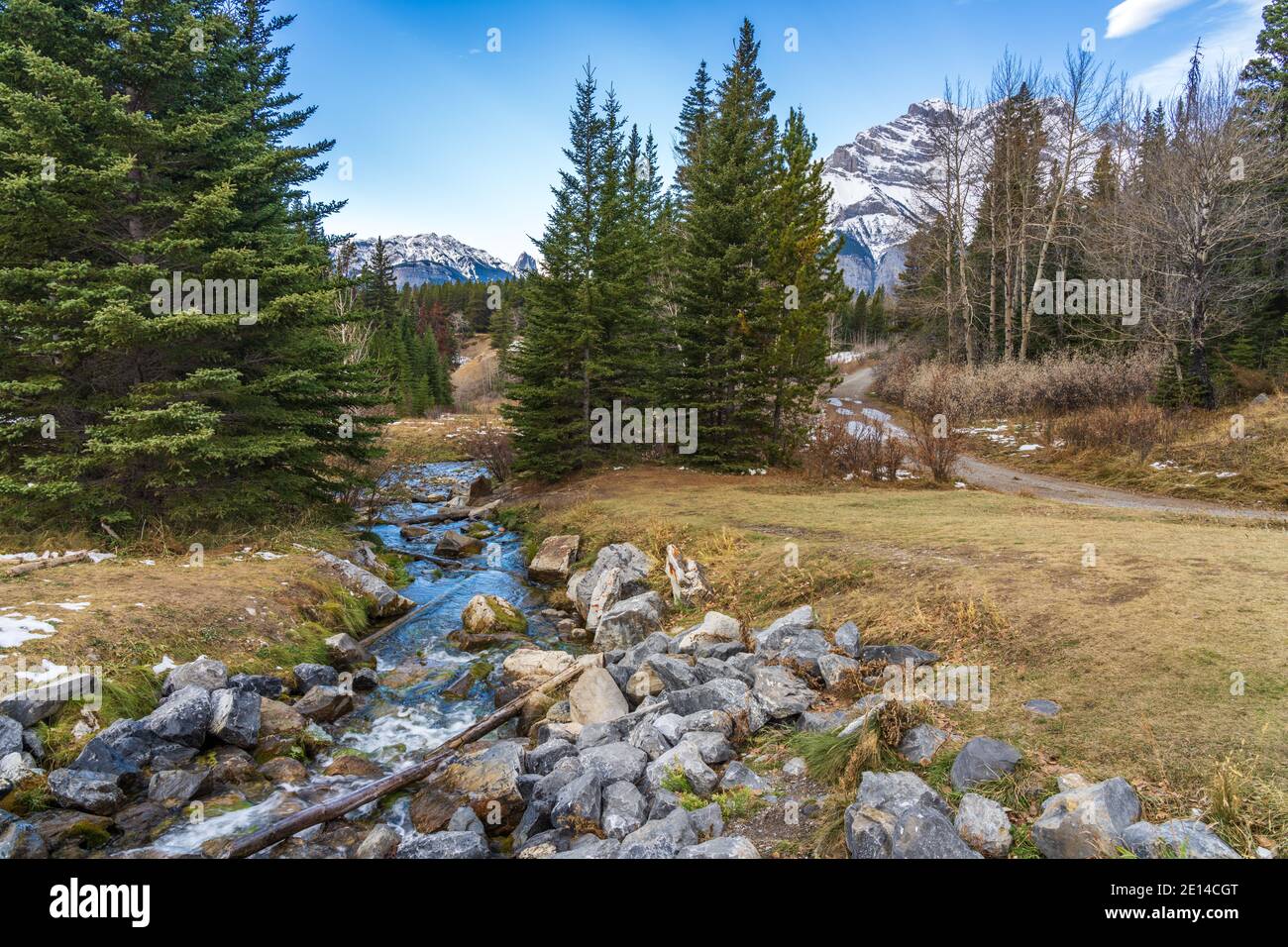 Small creek and walking trail in the forest with unmelted snow in ...