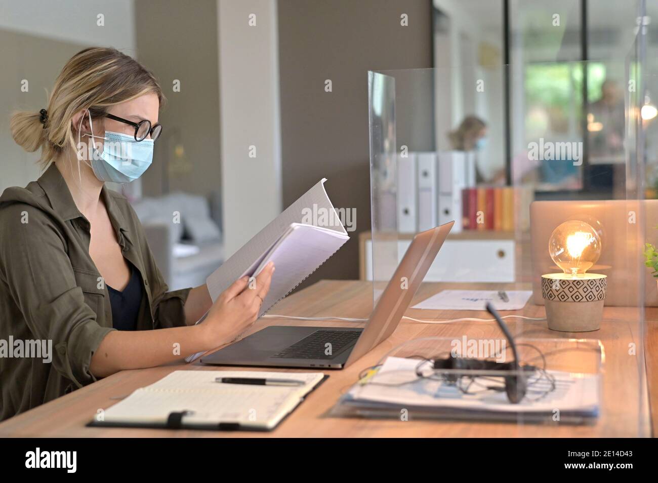 Office worker wearing surgical face mask in open space area Stock Photo ...