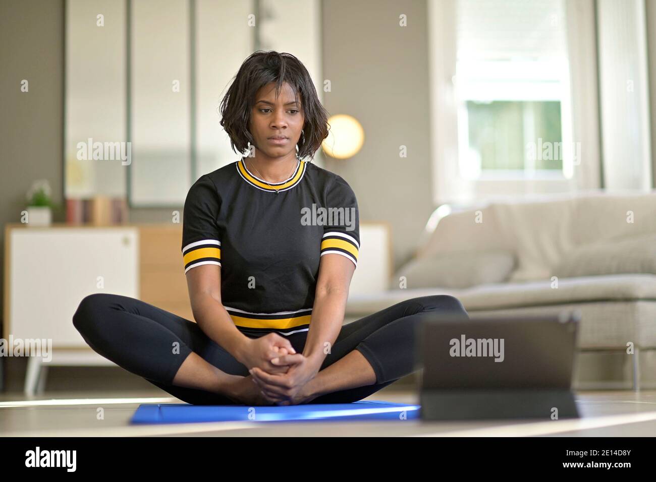 African-american woman doing virtual fitness exercices, digital class ...