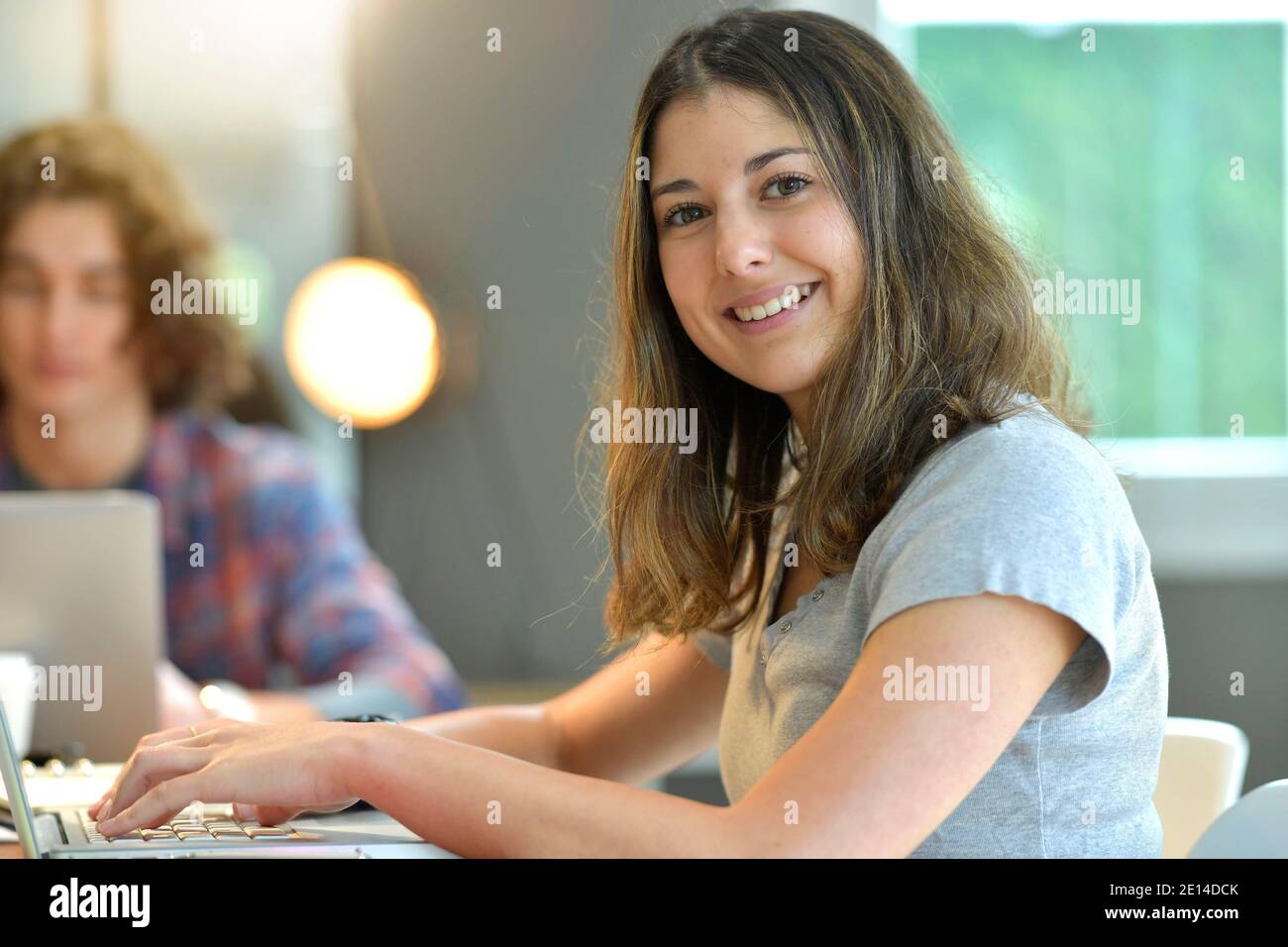 Portrait of smiling student working on laptop Stock Photo - Alamy