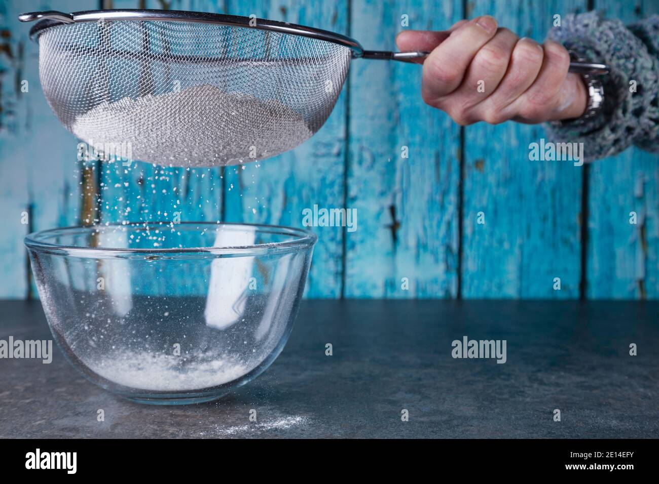 Mature lady sieving flour into a bowl in the kitchen Stock Photo - Alamy