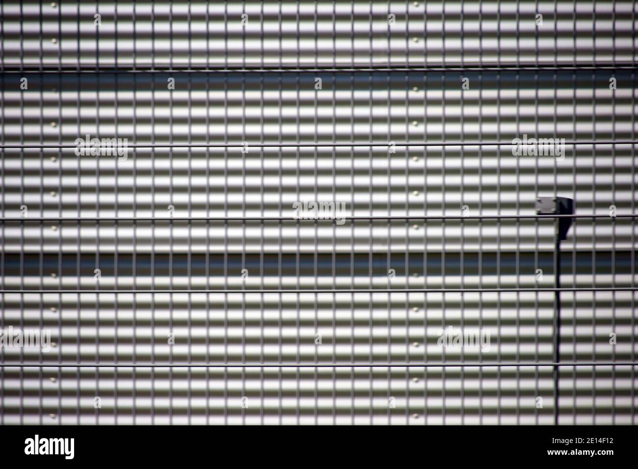 Grid Fence In Front Of Corrugated Iron Stock Photo - Alamy
