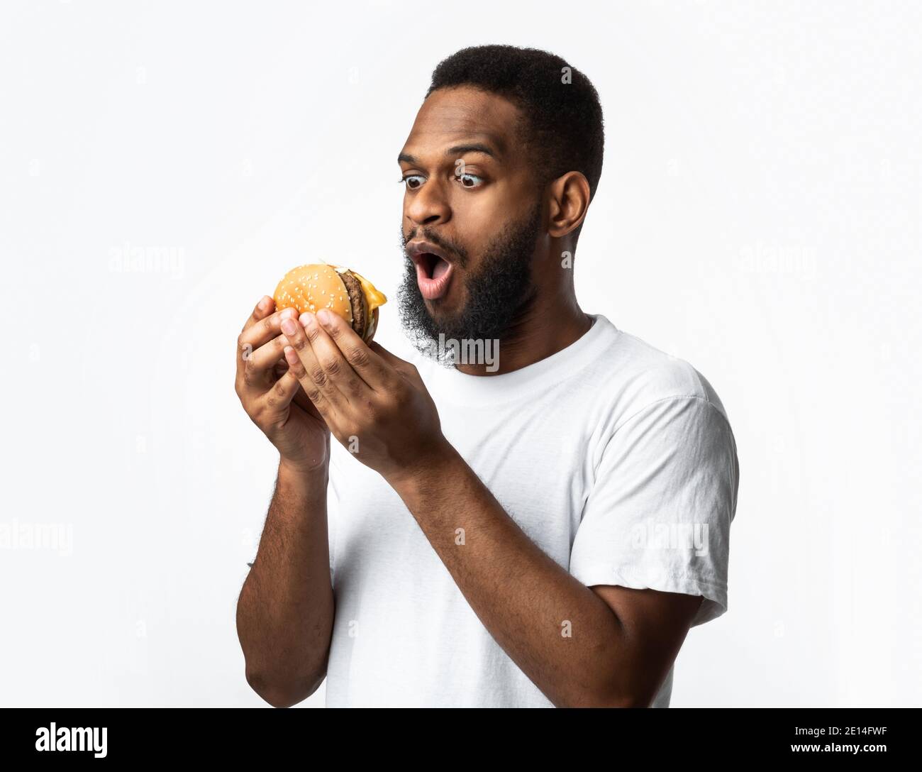 Excited Black Man Holding Burger Standing On White Studio Background ...