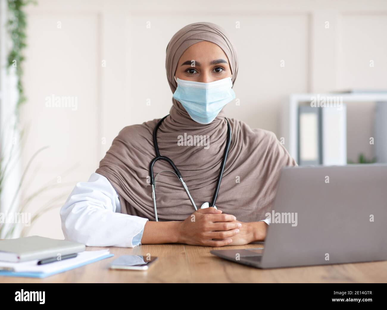 Beautiful muslim woman doctor in face mask in her cabinet Stock Photo ...