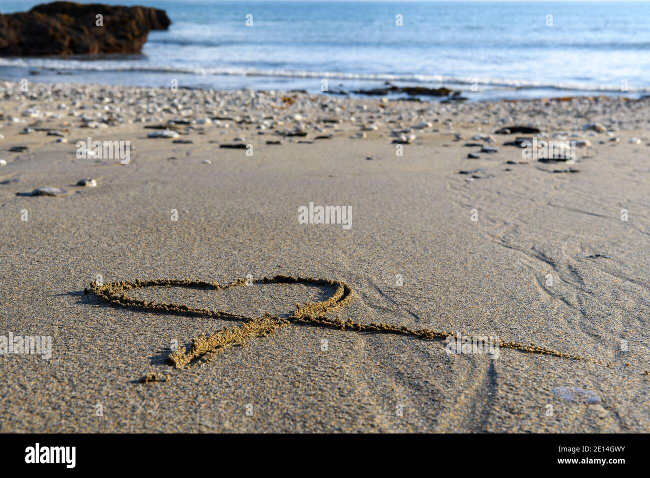 Heart shape drawn into the sand on a beach Stock Photo - Alamy
