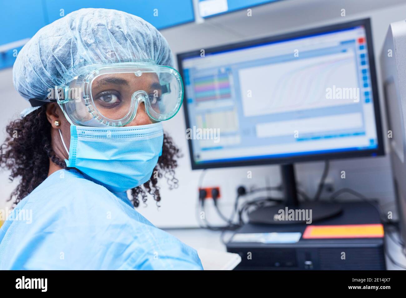 African woman as researcher in the laboratory at the computer analyzing ...