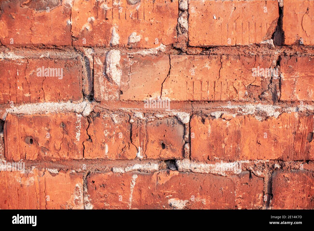 Old red brick wall. The bricks are laid in rows. Grunge stone texture ...