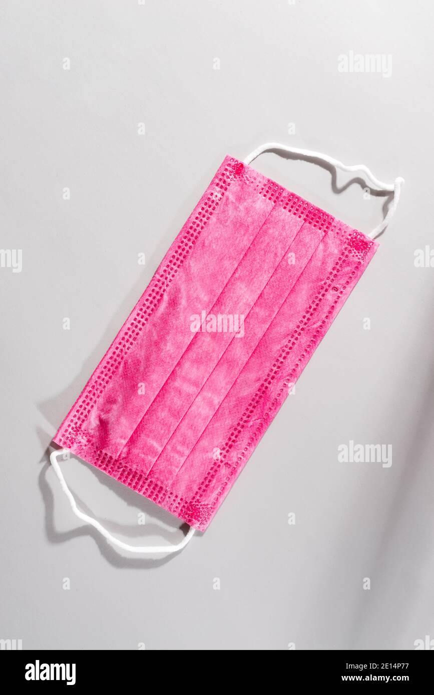 Surgical pink mask with rubber ear straps. Procedure mask from bacteria ...