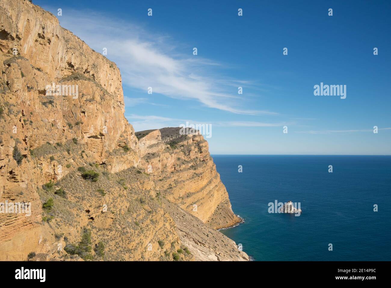 High rocky sea coast of Sierra Helada nature park with tiny island ...