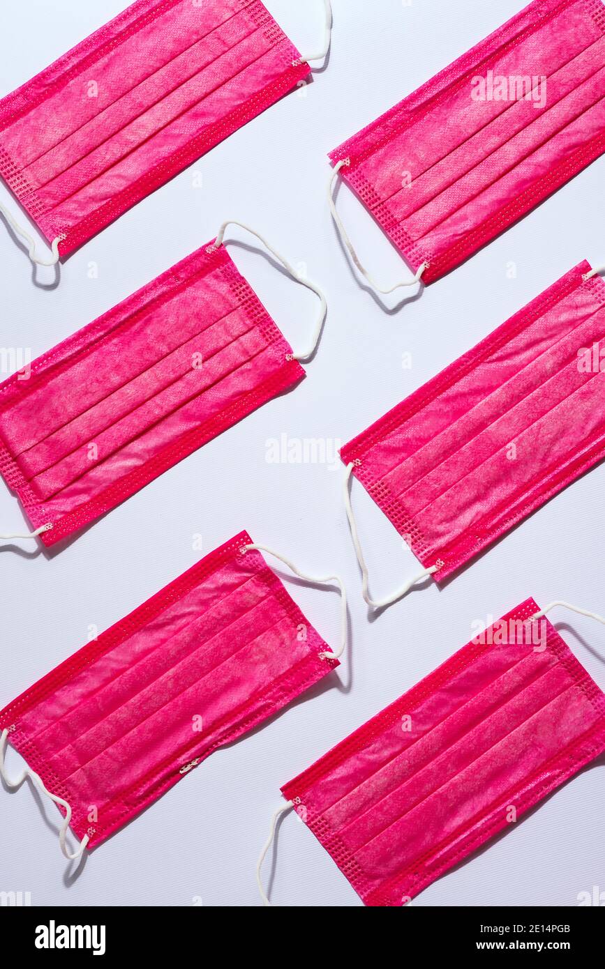 Surgical pink mask with rubber ear straps. Procedure mask from bacteria ...