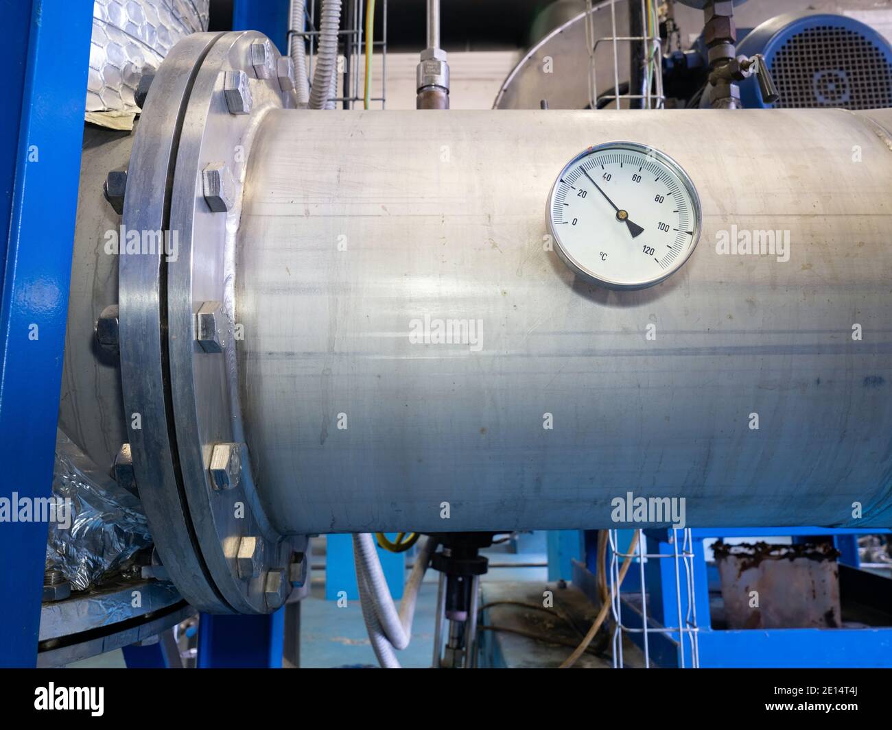 Measuring dial gauge. The measuring device against silver pipeline of a ...