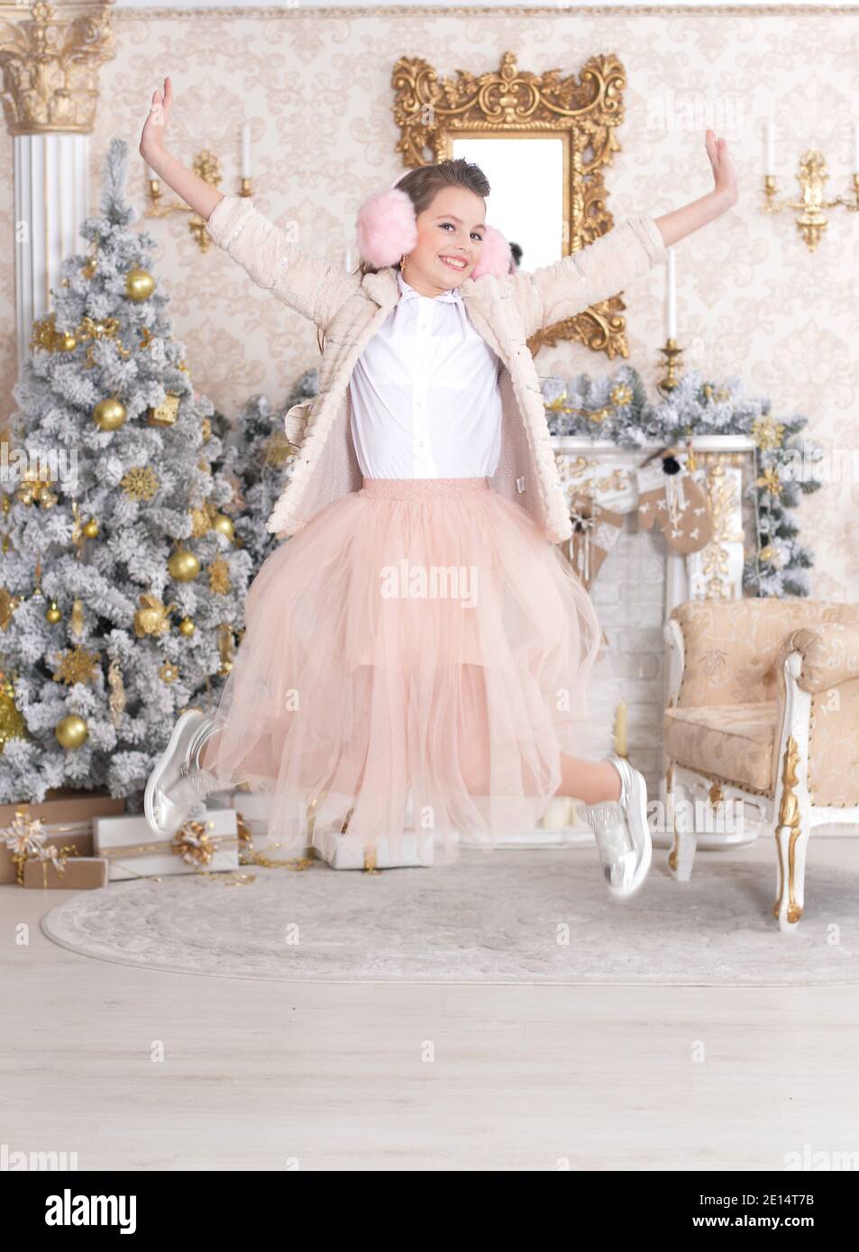Beautiful girl jumping hear Christmas tree at home Stock Photo - Alamy
