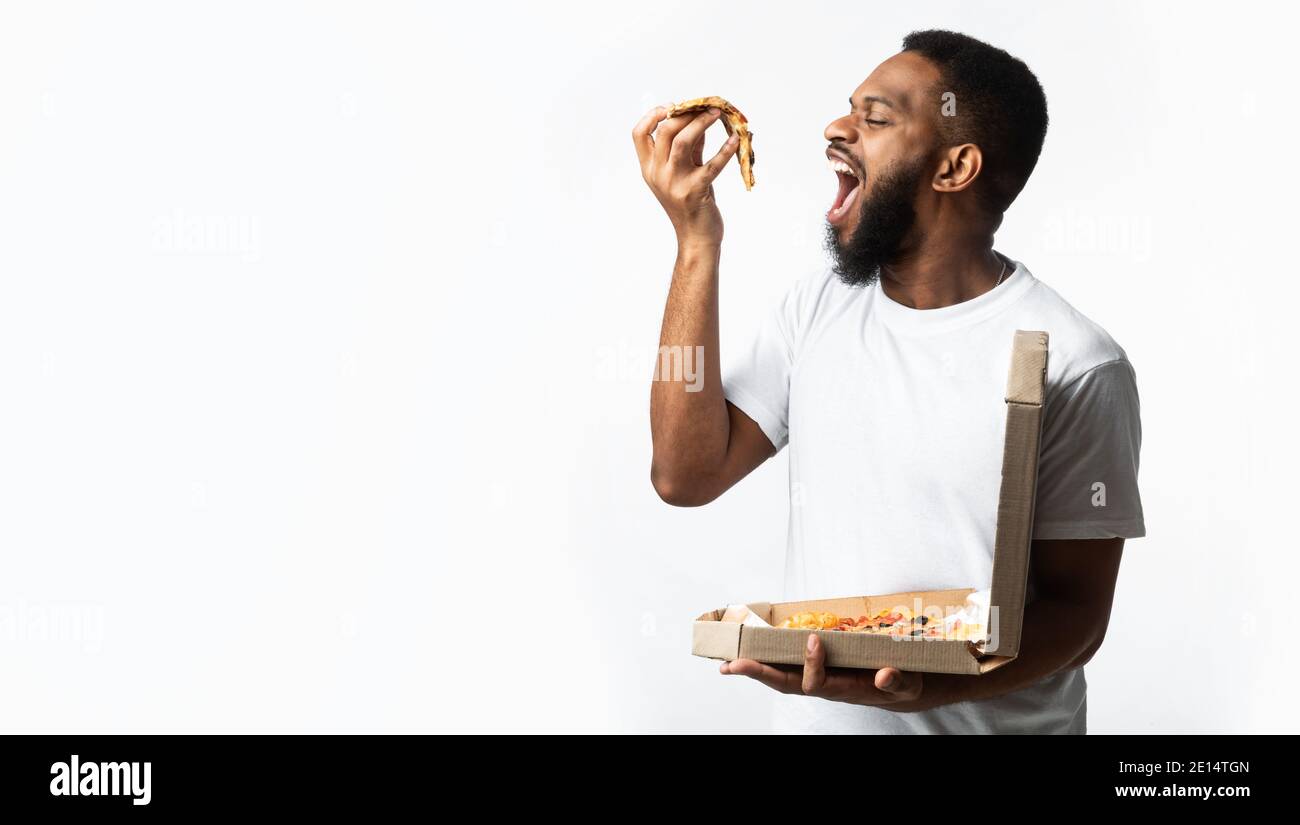 Side View Of African Man Eating Pizza Over White Background Stock Photo ...