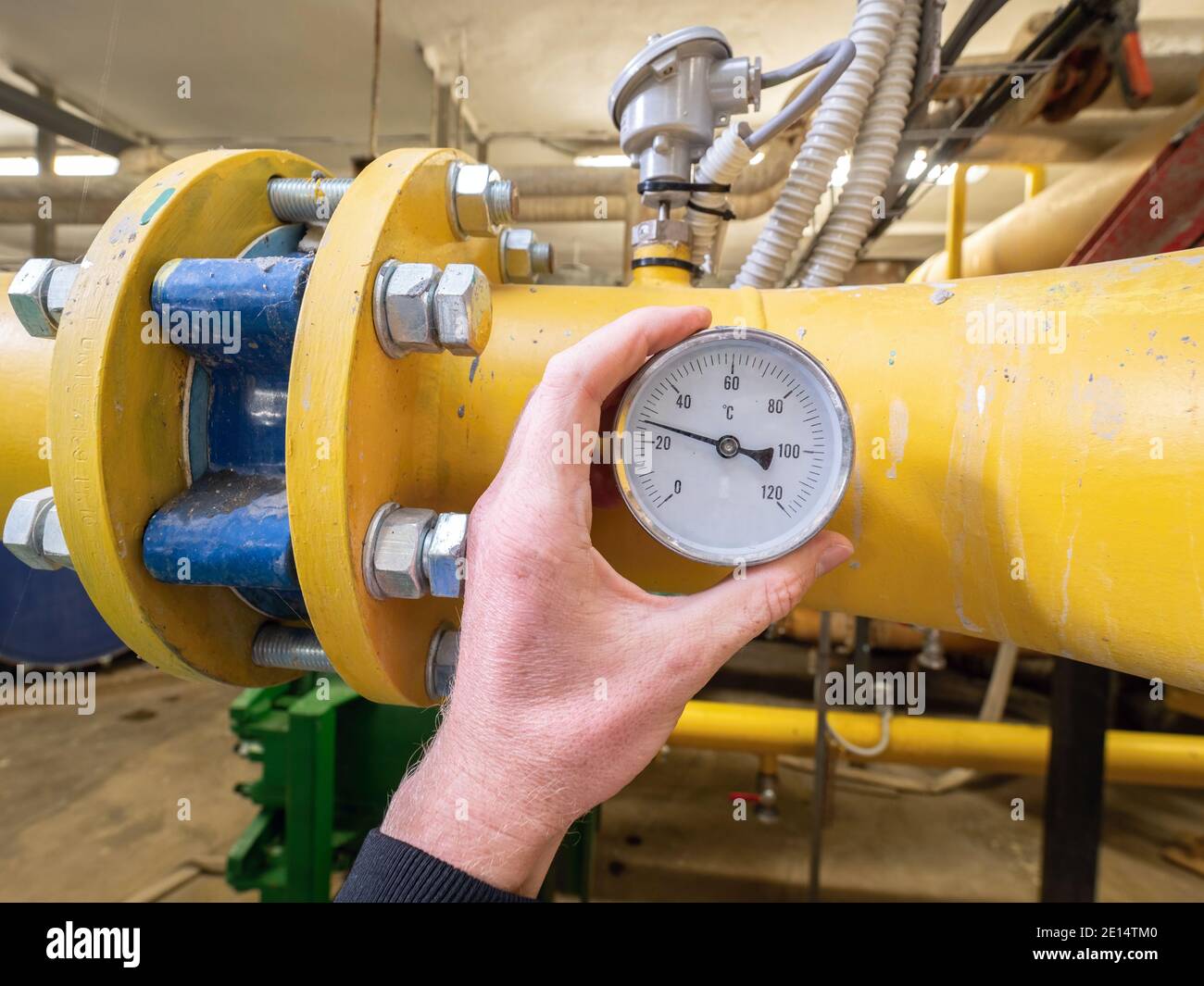 Controler hold in hand temperature gauges on yellow sludge pipe in ...