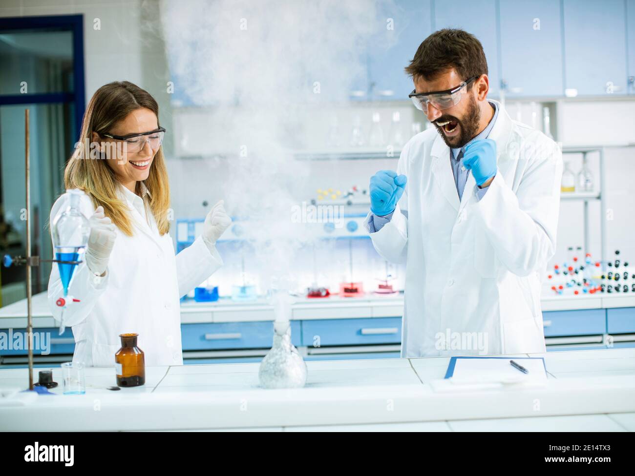 Young researchers doing experiment with smoke on a table of a chemical ...