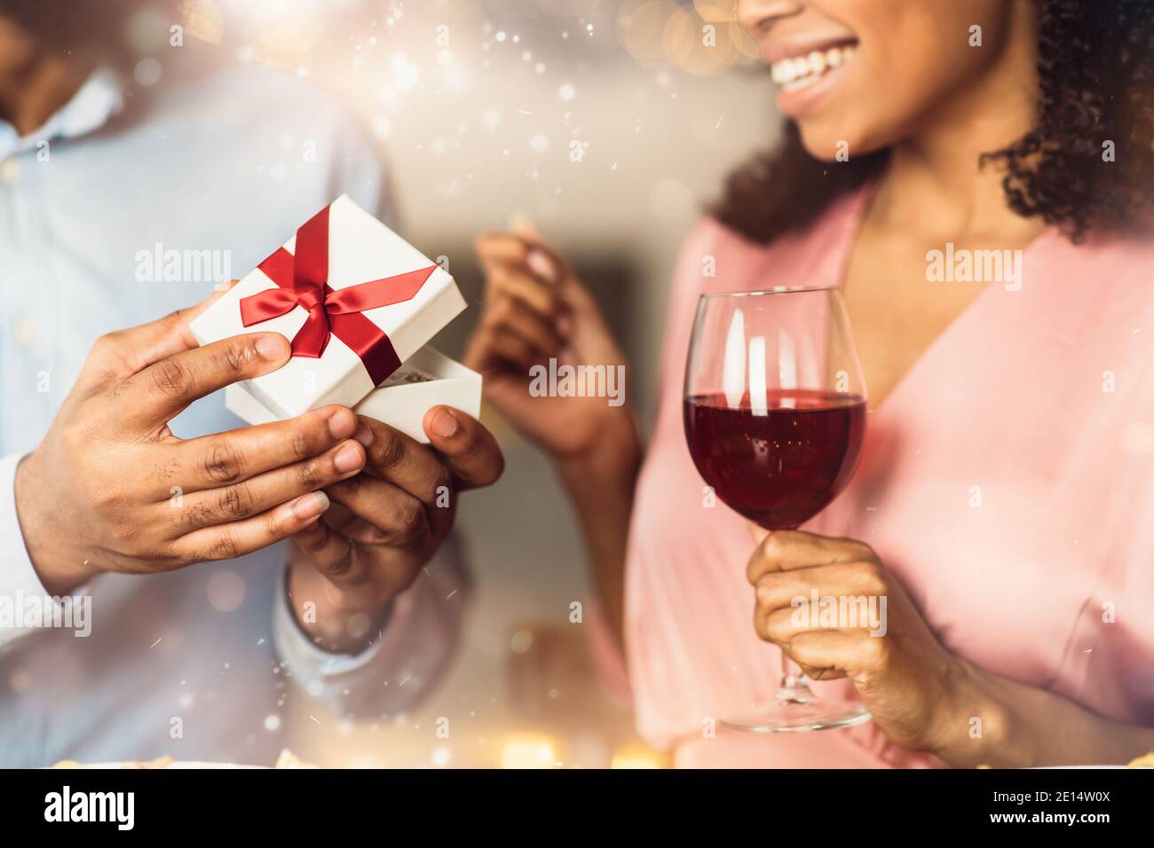 Young black man giving box with jewelry to his woman Stock Photo - Alamy