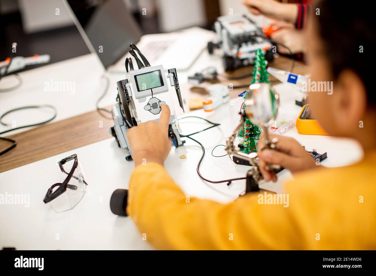 Cute little boy programming electric toys and robots at robotics ...