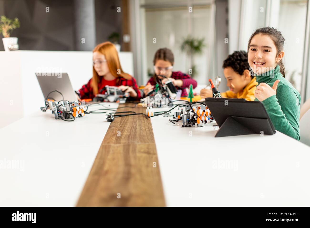 Group of happy kids programming electric toys and robots at robotics ...