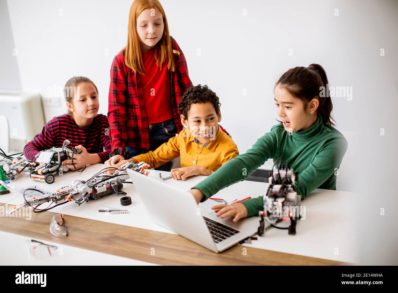 Group of happy kids programming electric toys and robots at robotics ...