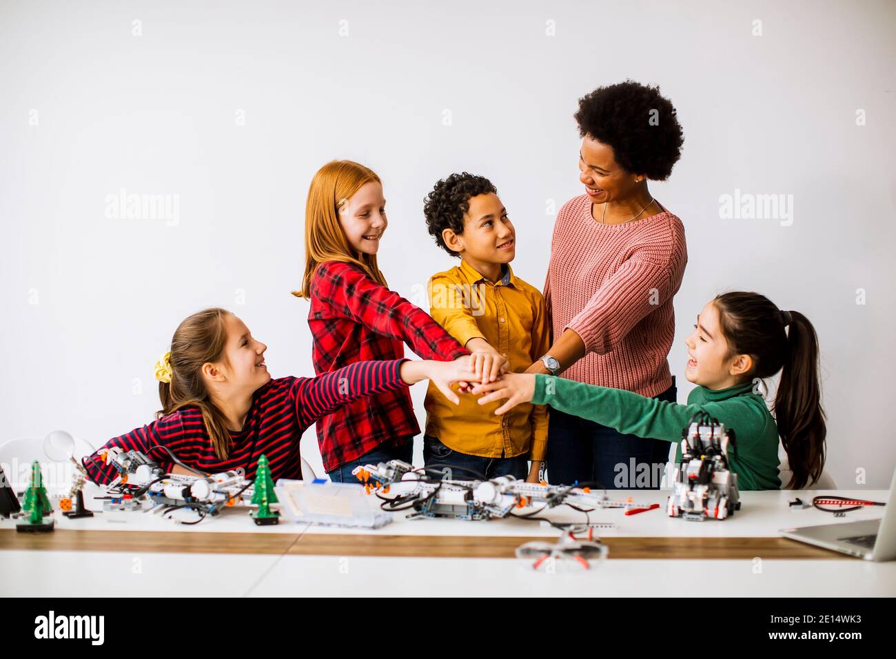 Group of happy kids with their African American female science teacher ...