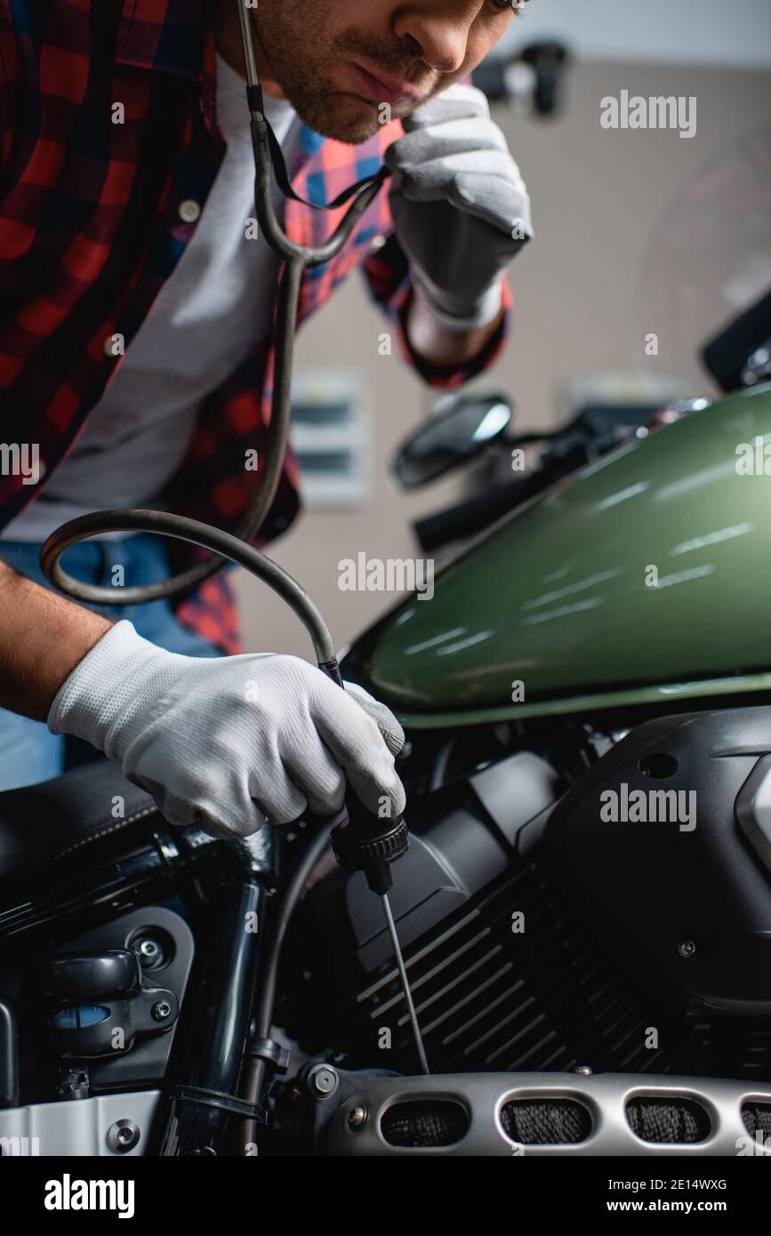 partial view of mechanic making diagnostics of motorcycle engine with ...