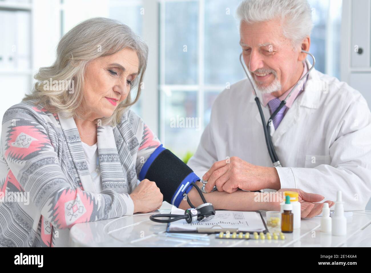 Portrait of elderly doctor measuring blood pressure Stock Photo - Alamy