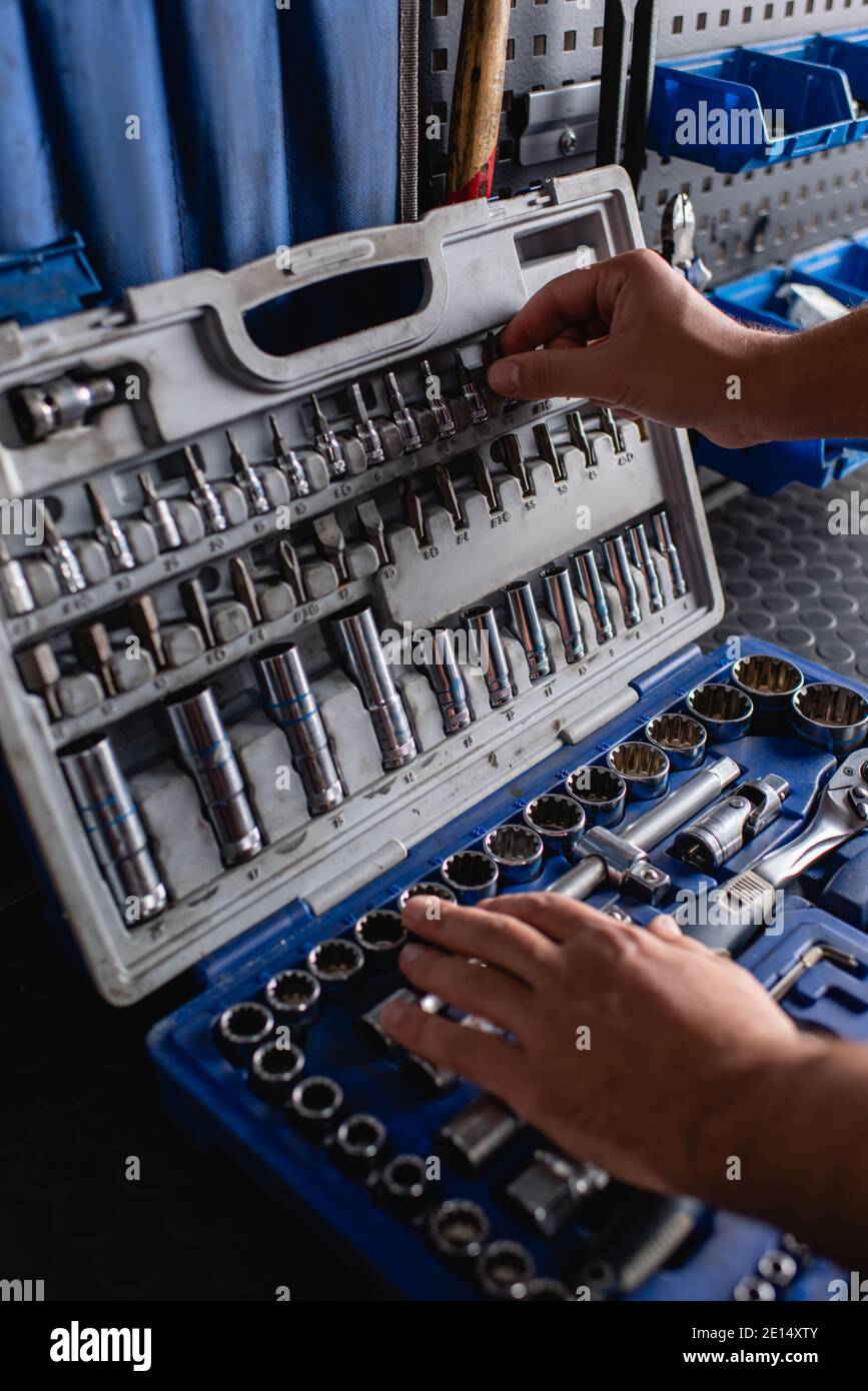 cropped view of mechanic choosing instrument in toolbox, blurred ...