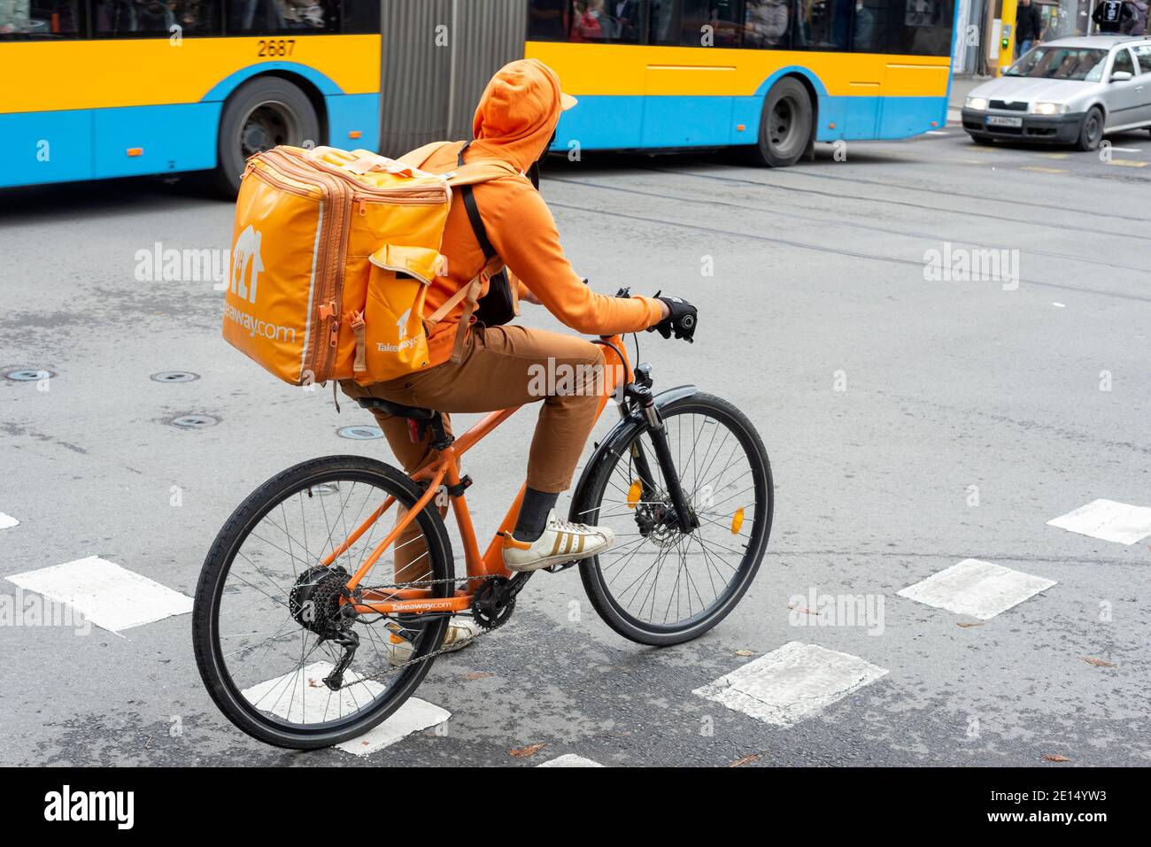 Fast food delivery male courier wearing the takeaway company orange ...