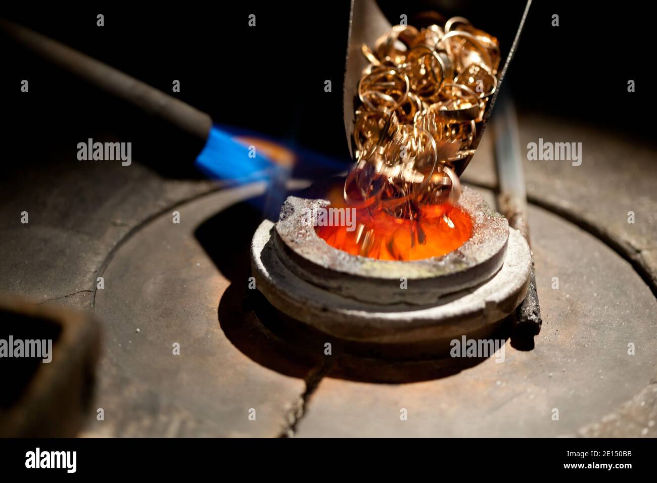 pieces of gold loaded into metallurgical furnace with fire for melting ...