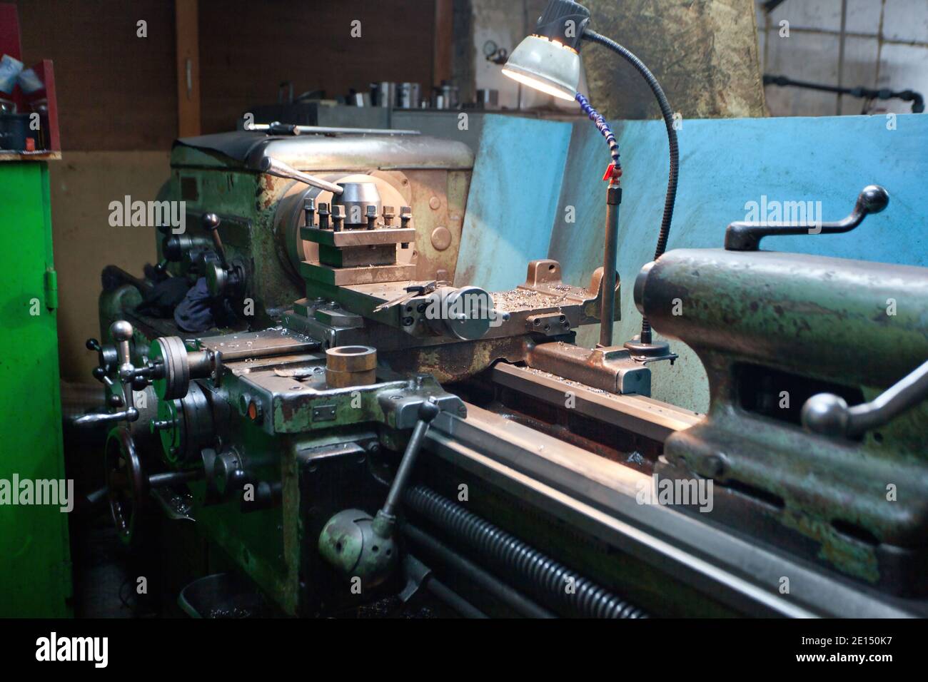 closeup of metallic lathe working against factory industrial interior ...