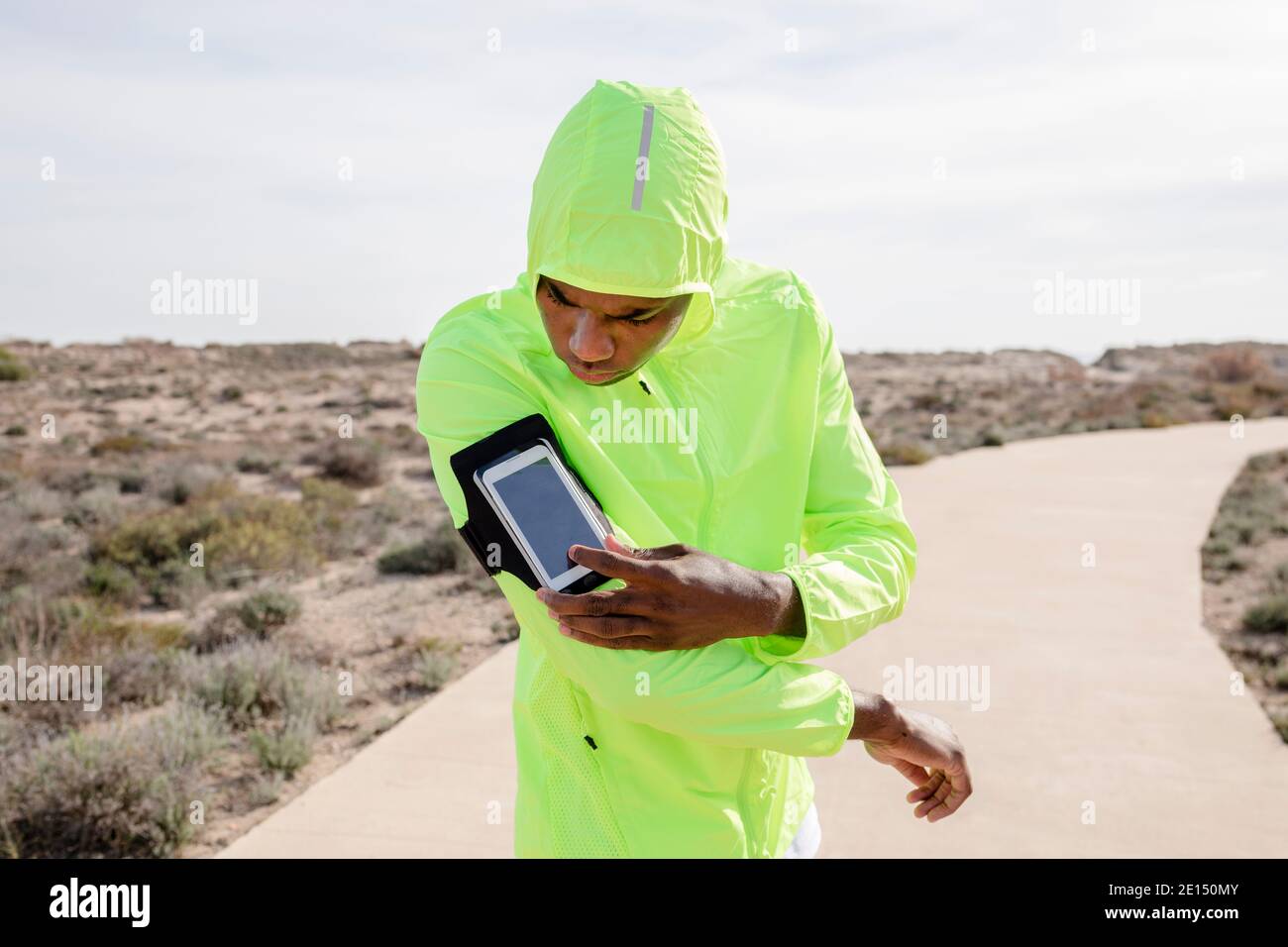 Smart phone running music closeup - black male runner listening to ...