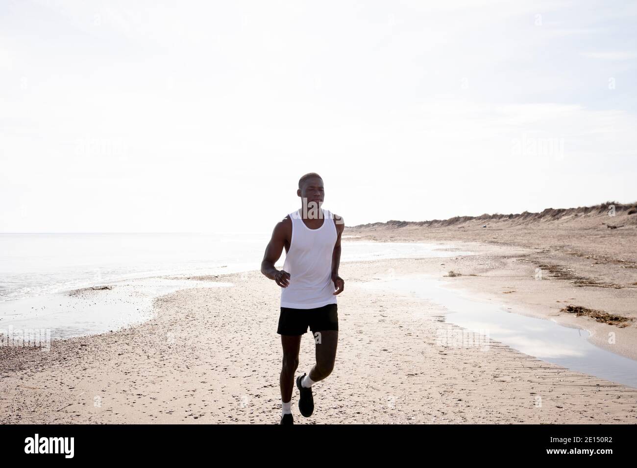 Young athletic man running beach hi-res stock photography and images ...