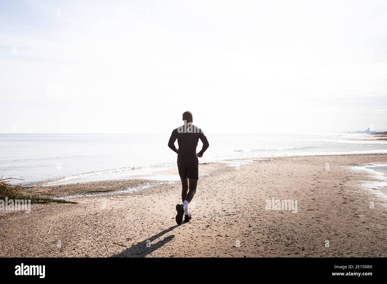 African boy who goes running on the beach against the light. Concept of ...