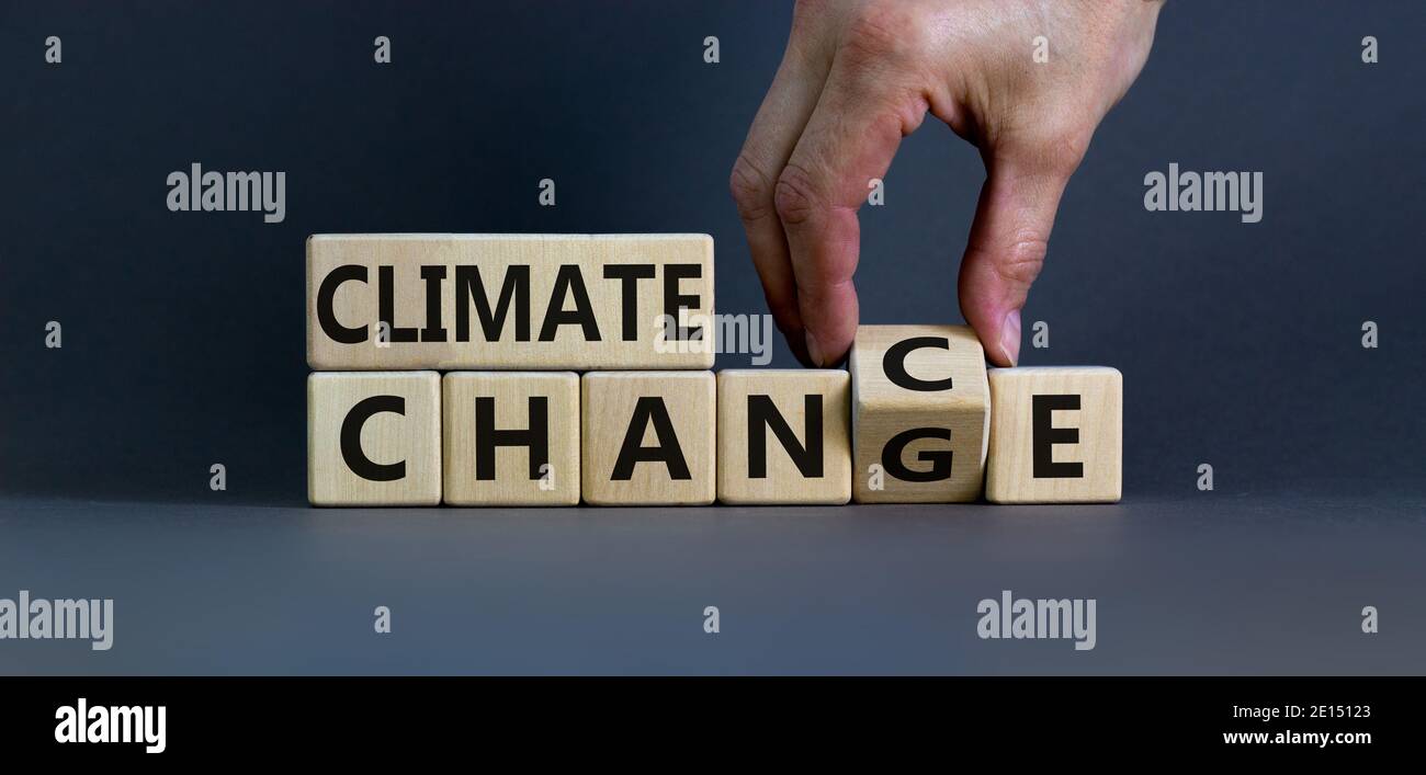 Climate change symbol. Hand flips a cube and changes words 'climate ...