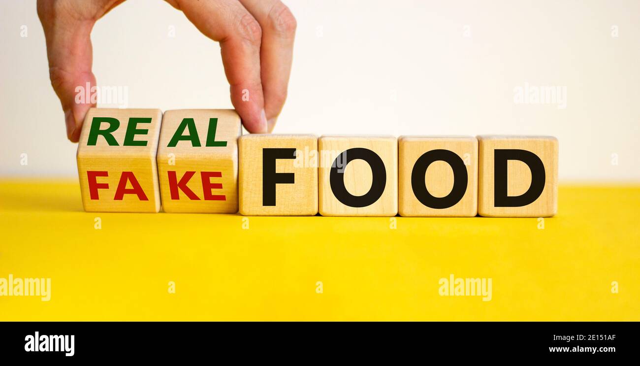 Real or fake food symbol. Male hand flips wooden cubes and changes ...