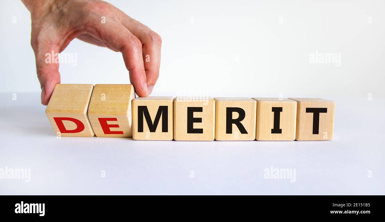 Demerit or merit symbol. Male hand flips wooden cubes and changes words ...